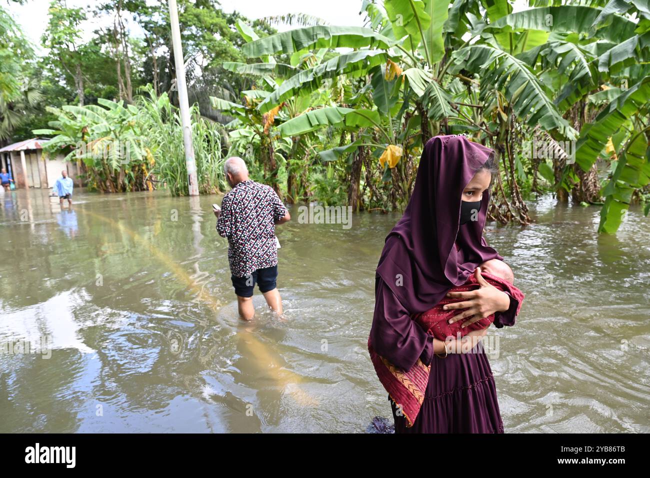 People wade through floodwaters in Feni District, Bangladesh, on August ...