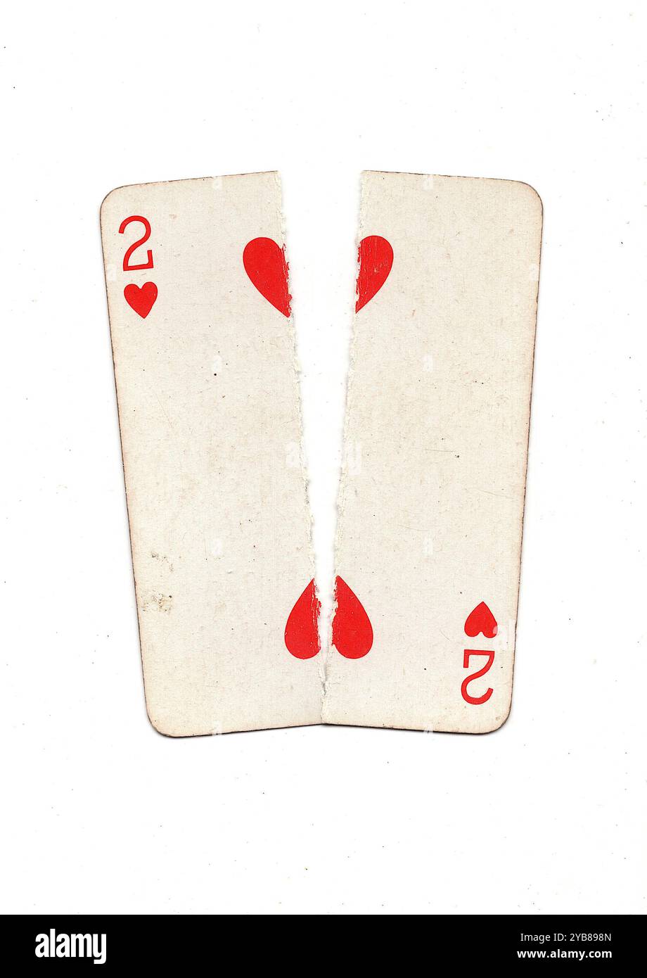 A vintage playing card torn in half from top to bottom on a white ...