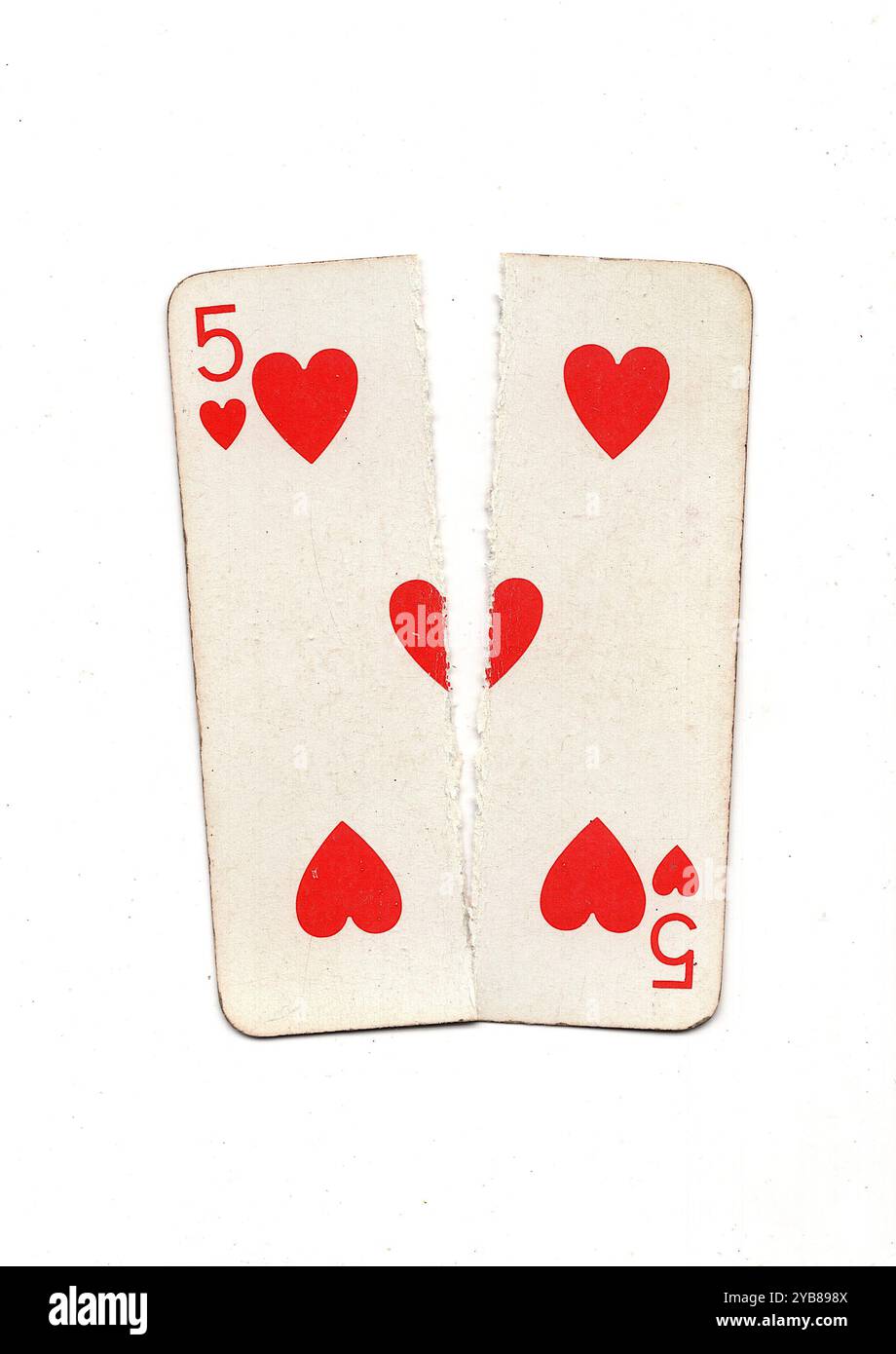A vintage playing card torn in half from top to bottom on a white ...