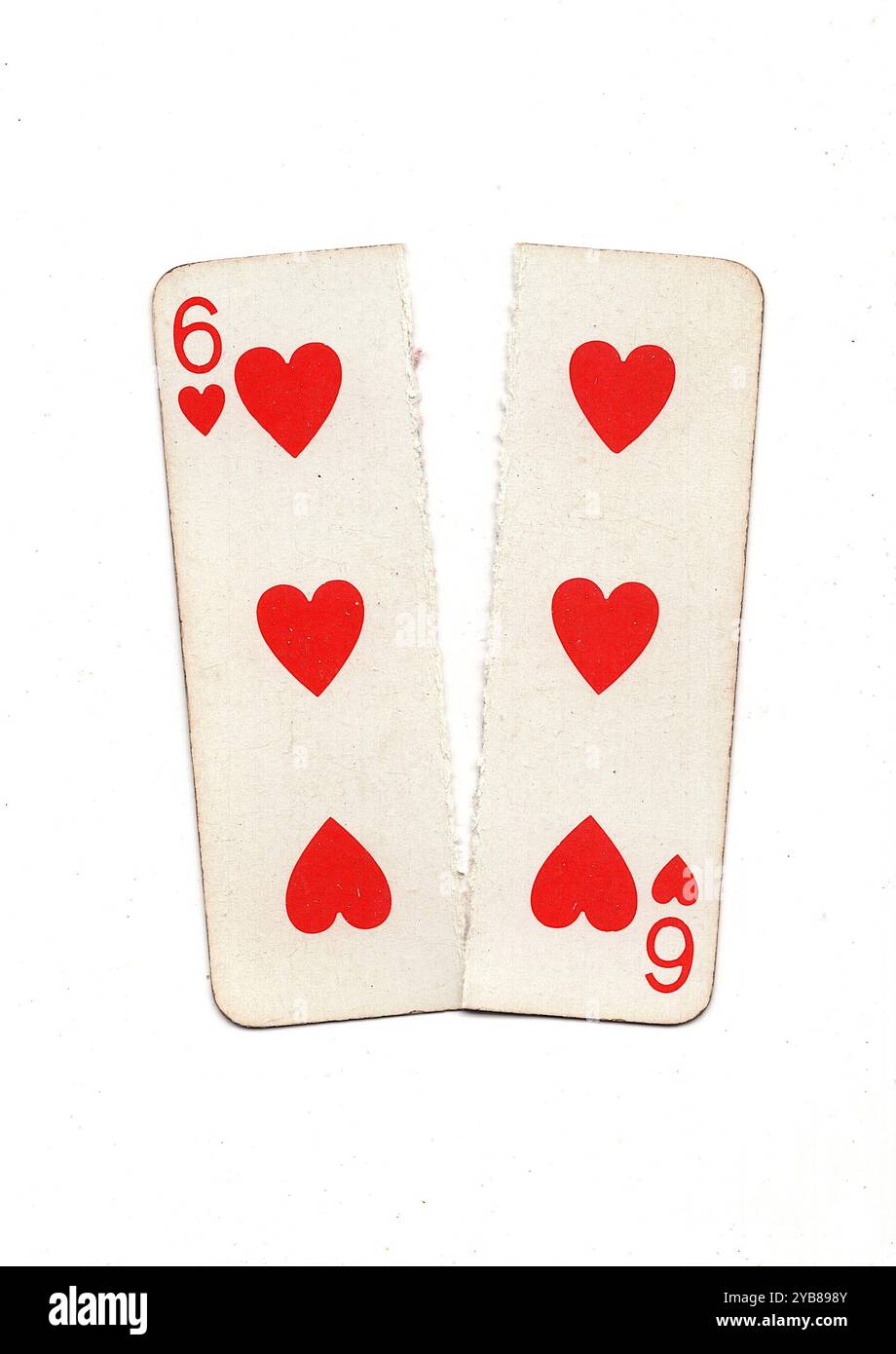 A vintage playing card torn in half from top to bottom on a white ...