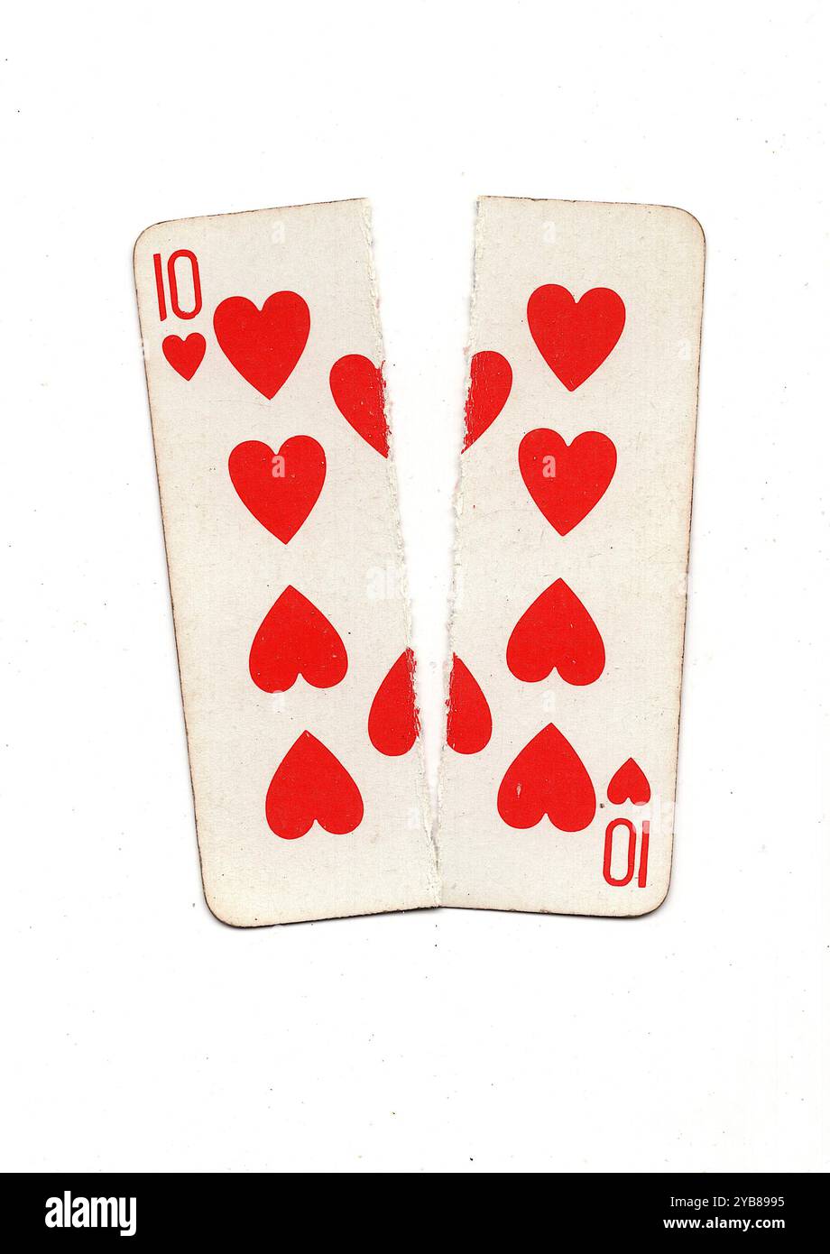 A vintage playing card torn in half from top to bottom on a white ...