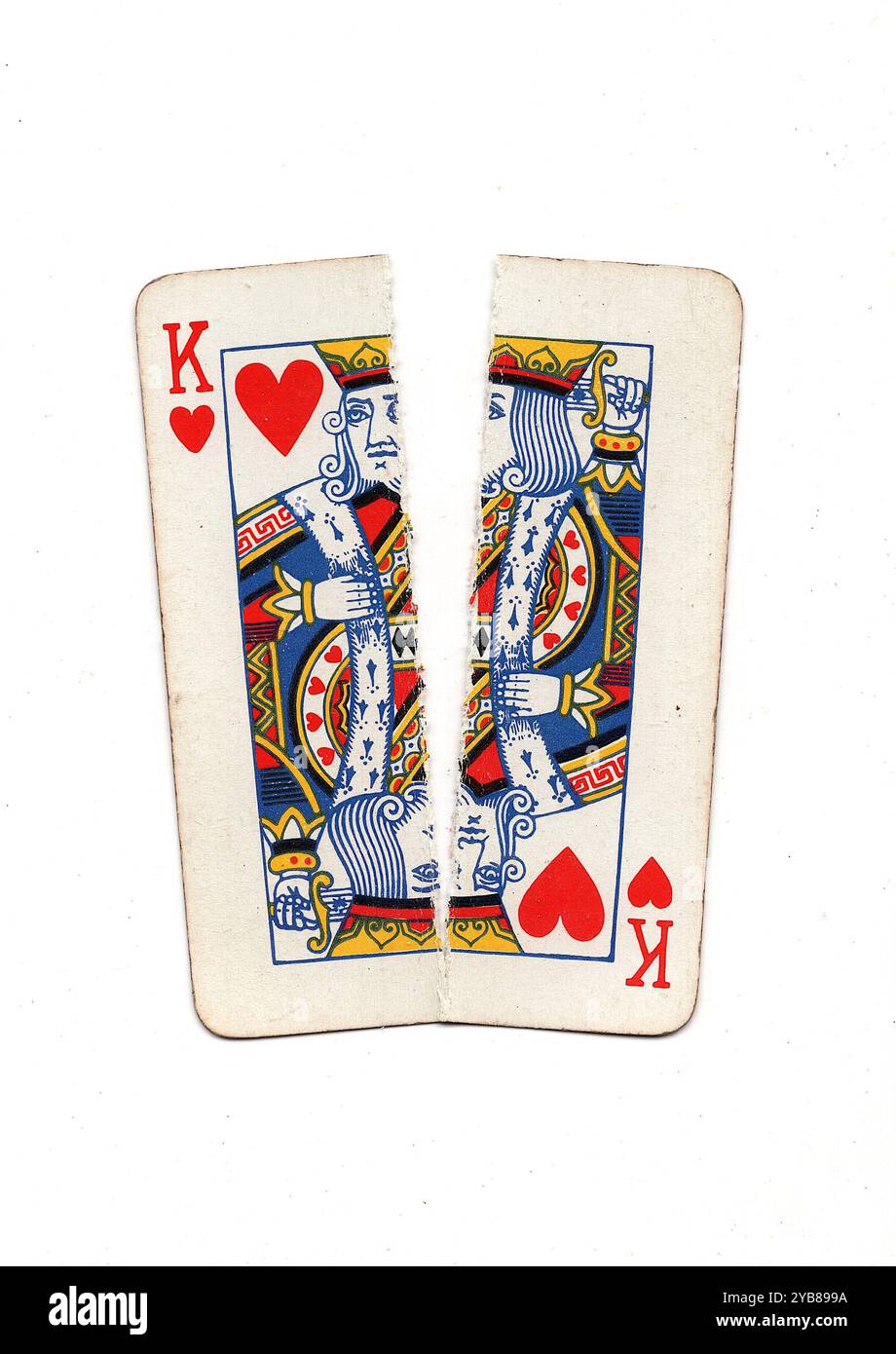 A vintage playing card torn in half from top to bottom on a white ...