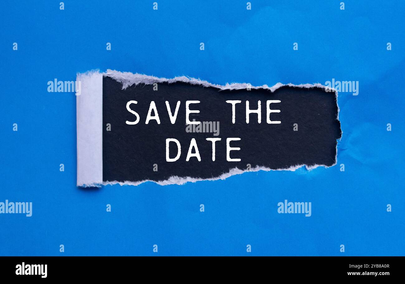 Save the date message written on ripped torn blue paper with black background. Conceptual save ...