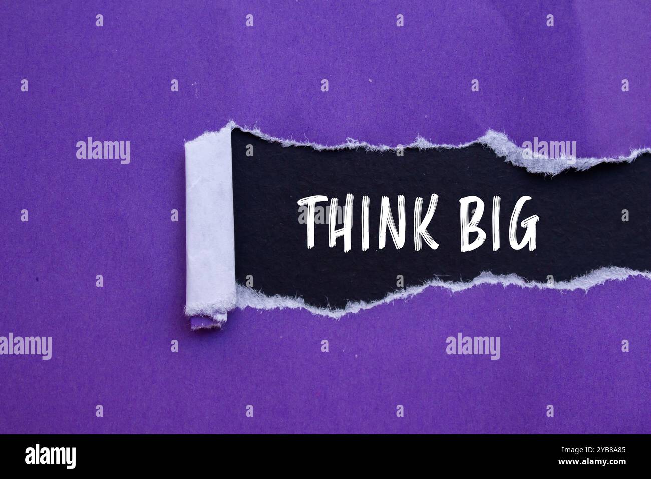 Think big message written on ripped purple torn paper with black ...