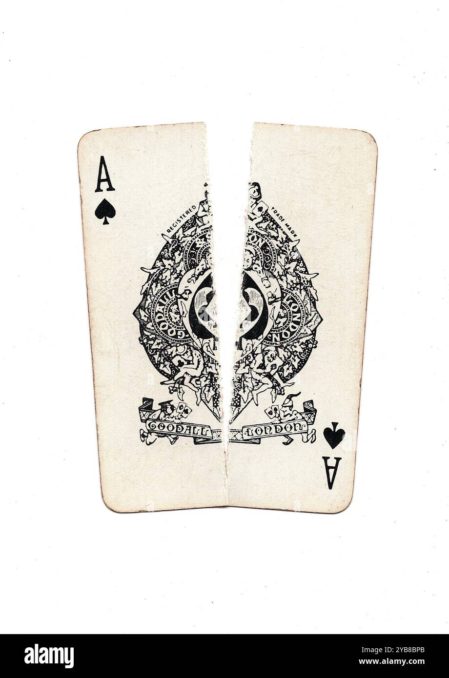 A vintage playing card torn in half from top to bottom on a white ...
