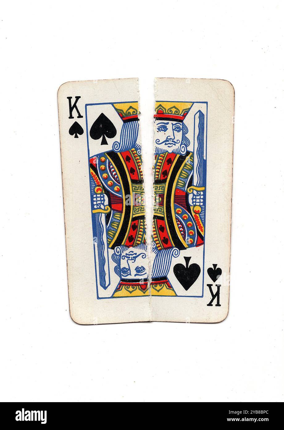 A vintage playing card torn in half from top to bottom on a white ...