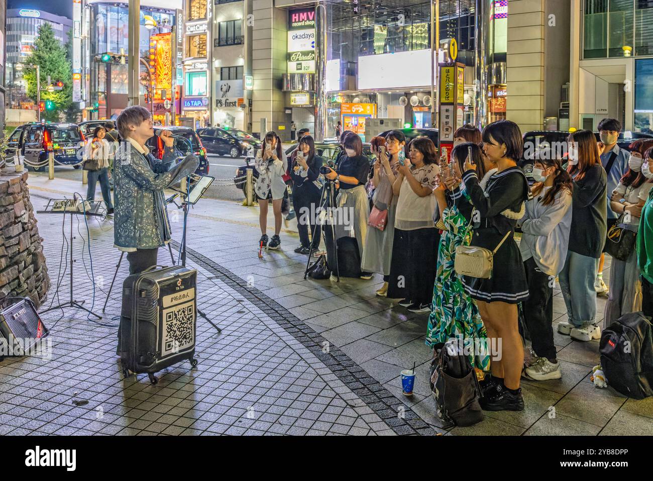 Japanese boy busker singing to audience of adoring young women all with ...