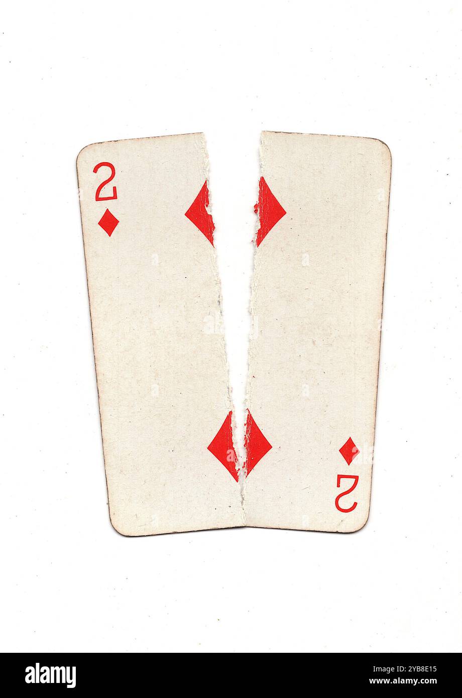 A vintage playing card torn in half from top to bottom on a white ...