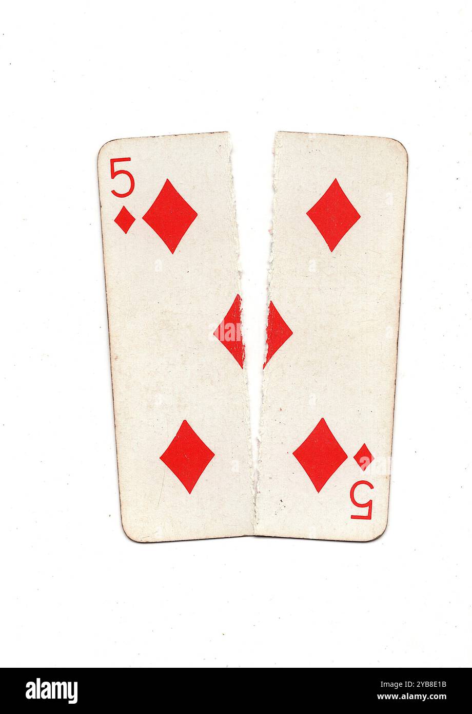 A vintage playing card torn in half from top to bottom on a white ...
