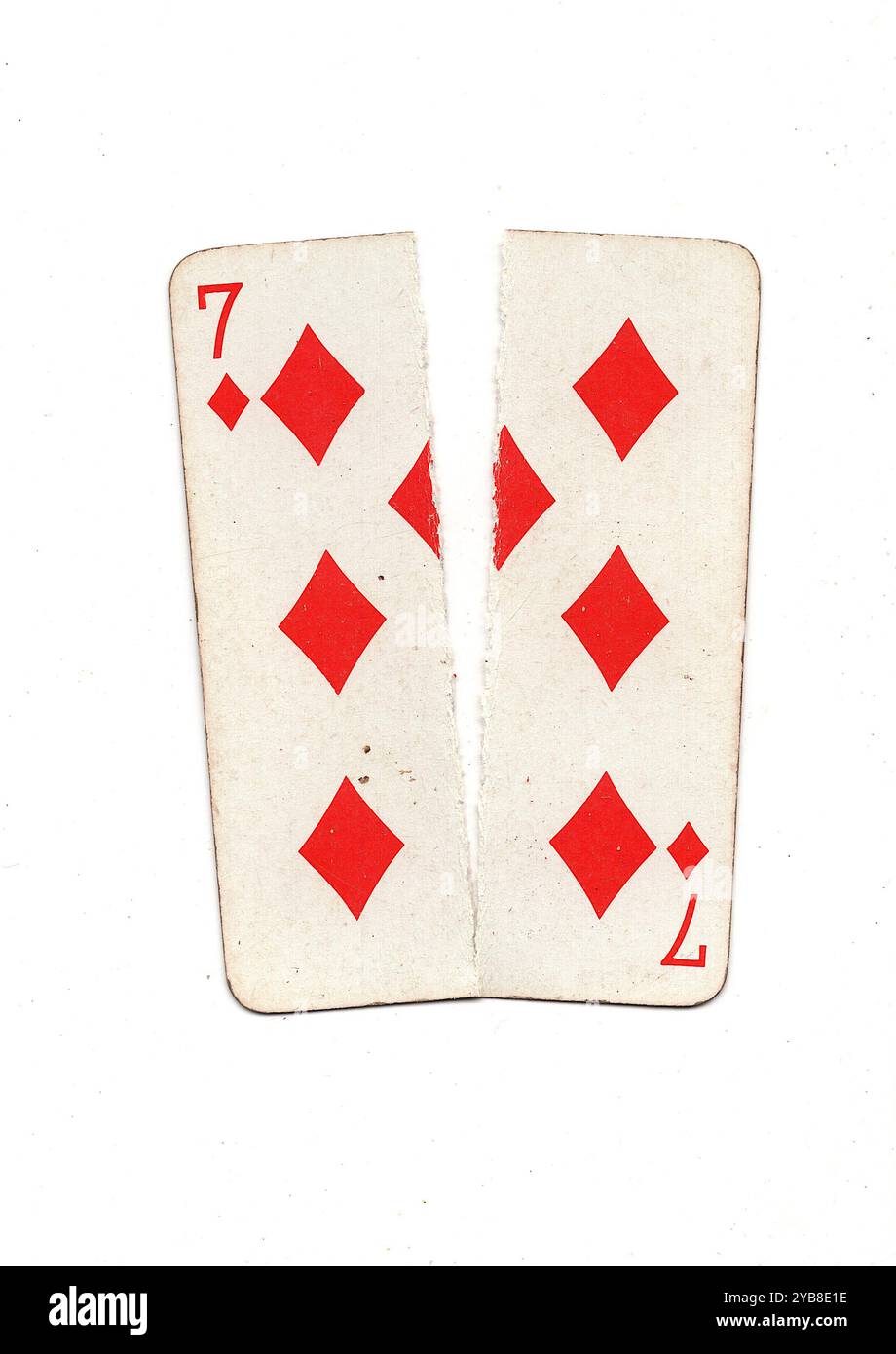 A vintage playing card torn in half from top to bottom on a white ...