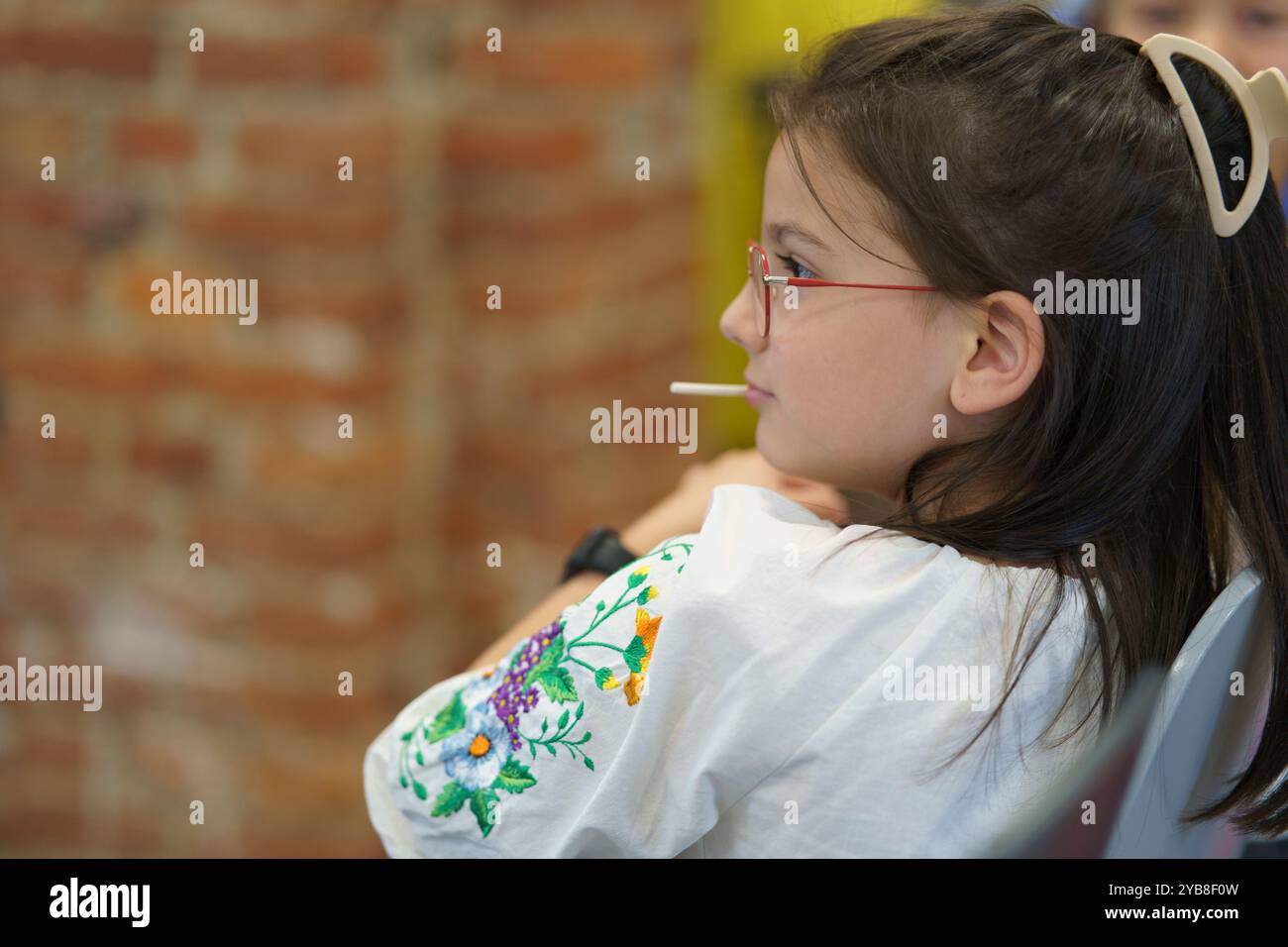 A little smiling girl with glasses in a traditional ukrainian ...