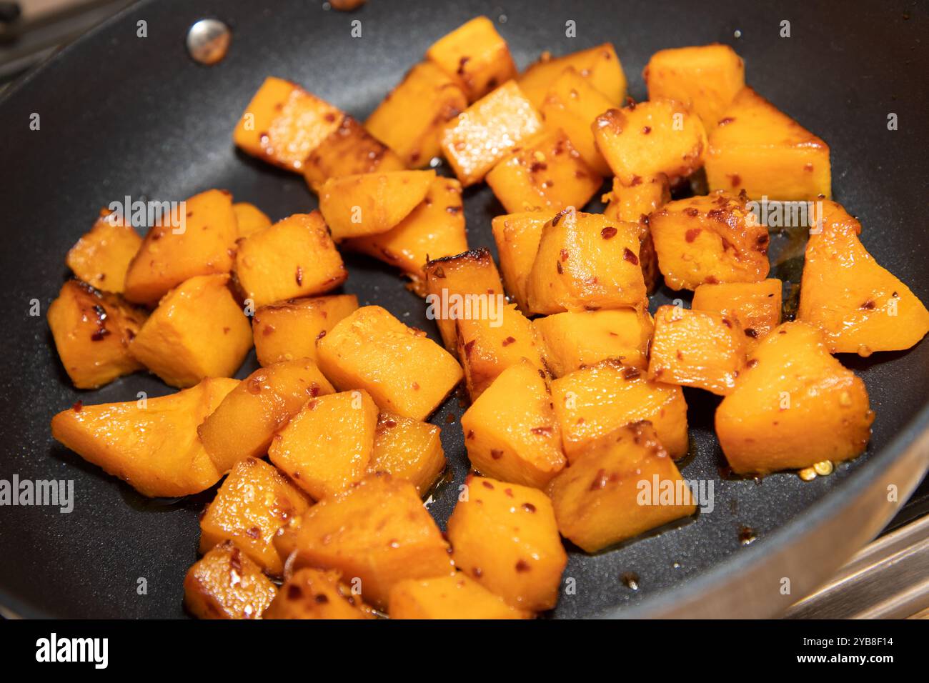 Diced butternut squash being cooked in a pan ready to be put in a dish ...
