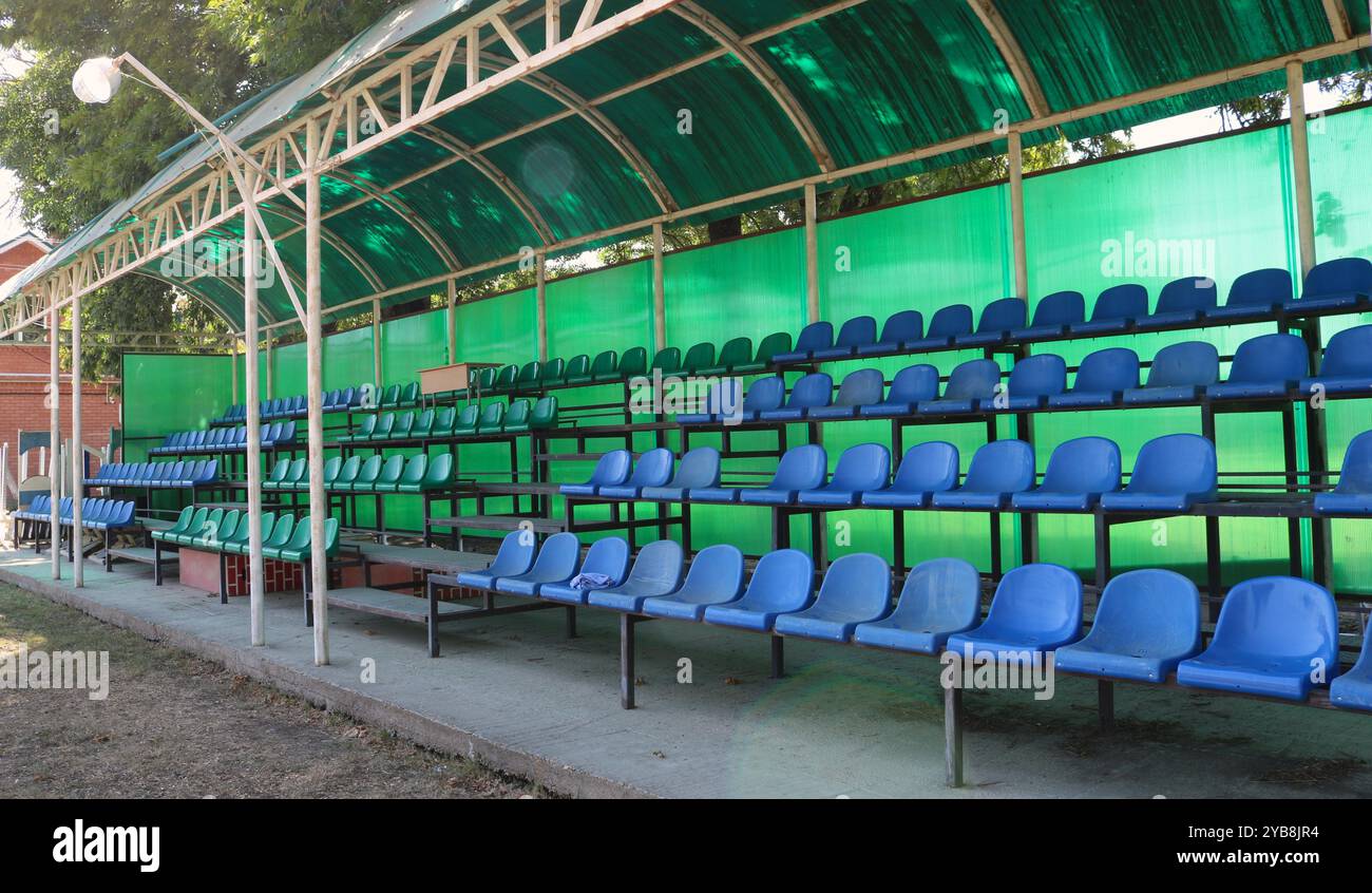 blue and green plastic chairs under a green canopy, a fragment of an ...