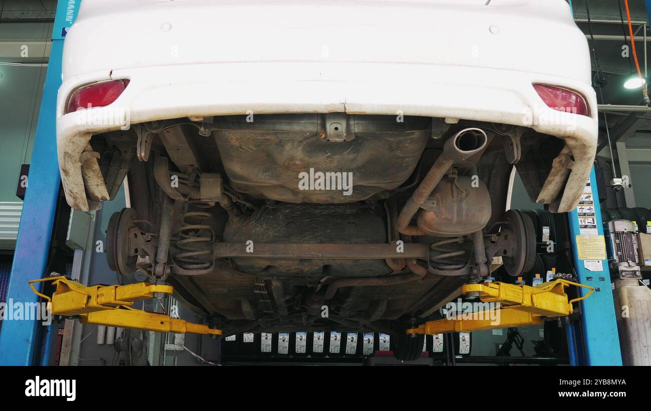 Car in repair workshop lifted on hoist, mechanic's perspective of Stock ...