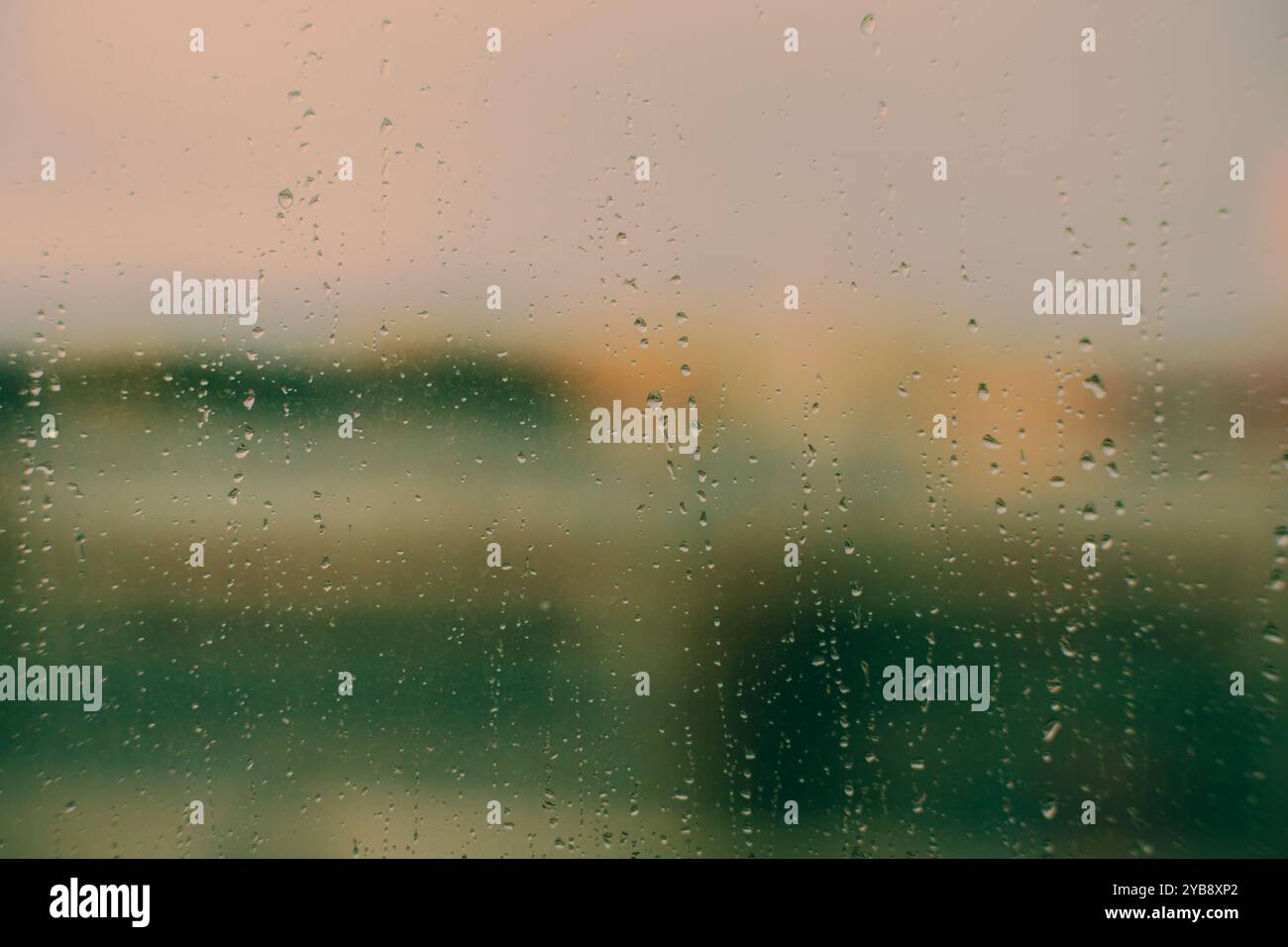 The window glass is covered in a thin layer of water from the rain. A ...