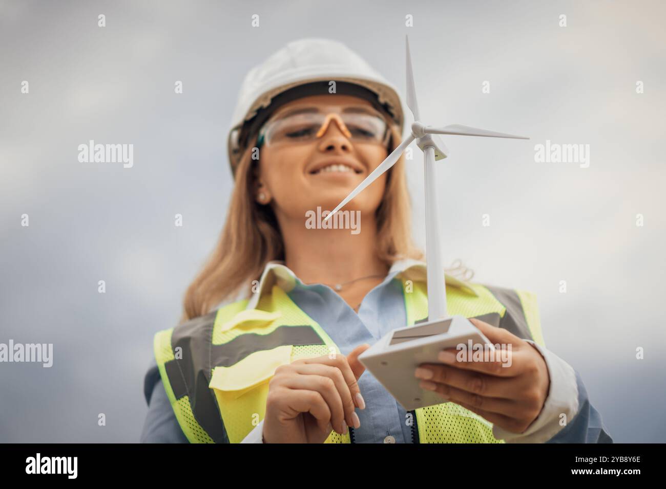 A Proud Engineer Holding a Wind Turbine Model A Strong Symbol of the ...