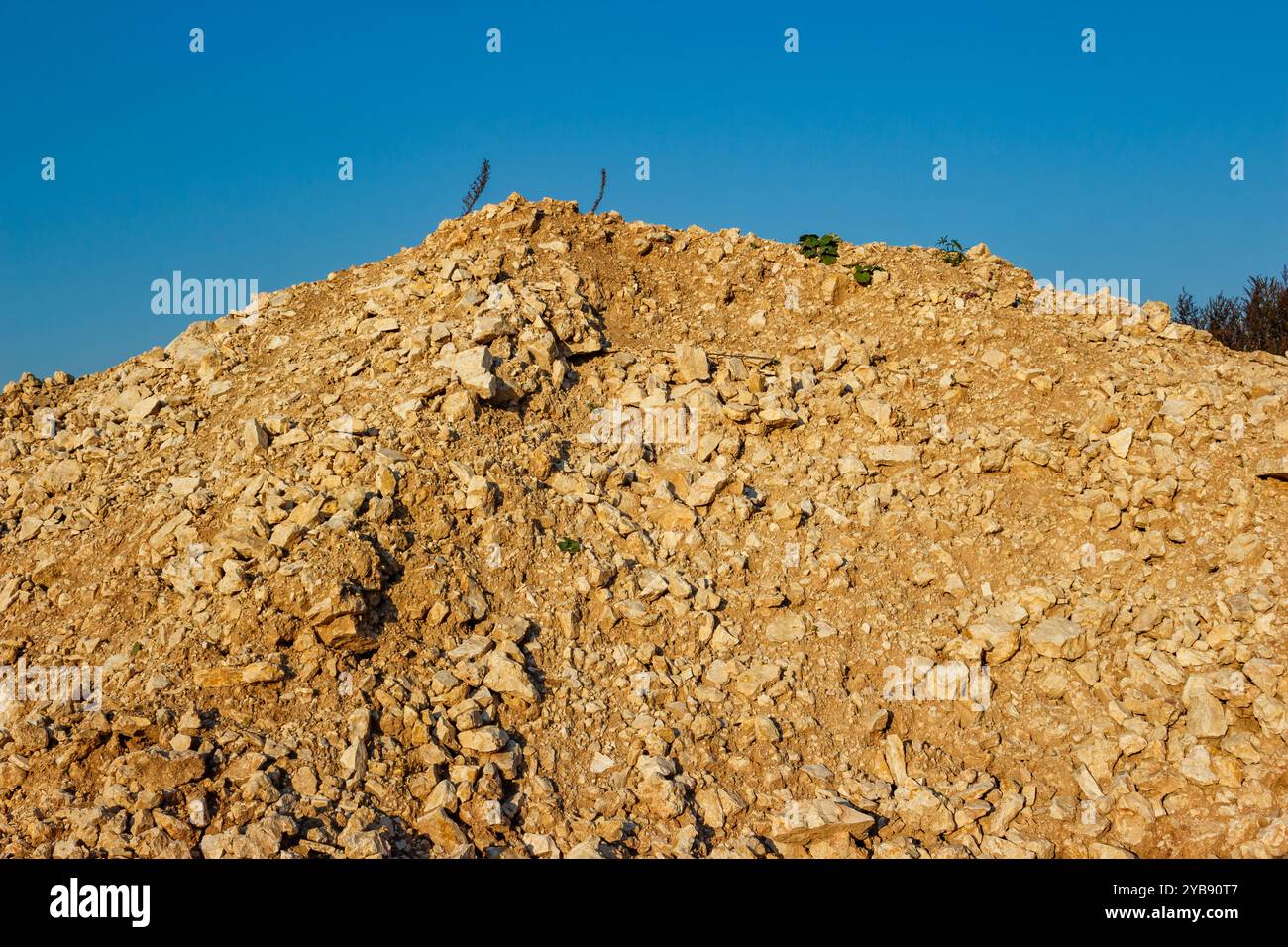A pile of rubble against a blue sky, limestone crushed stone production ...
