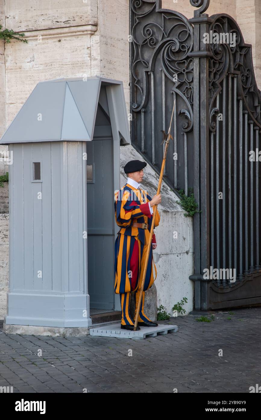 Papal Swiss Guard in uniform with a halberd standing at the door in the ...