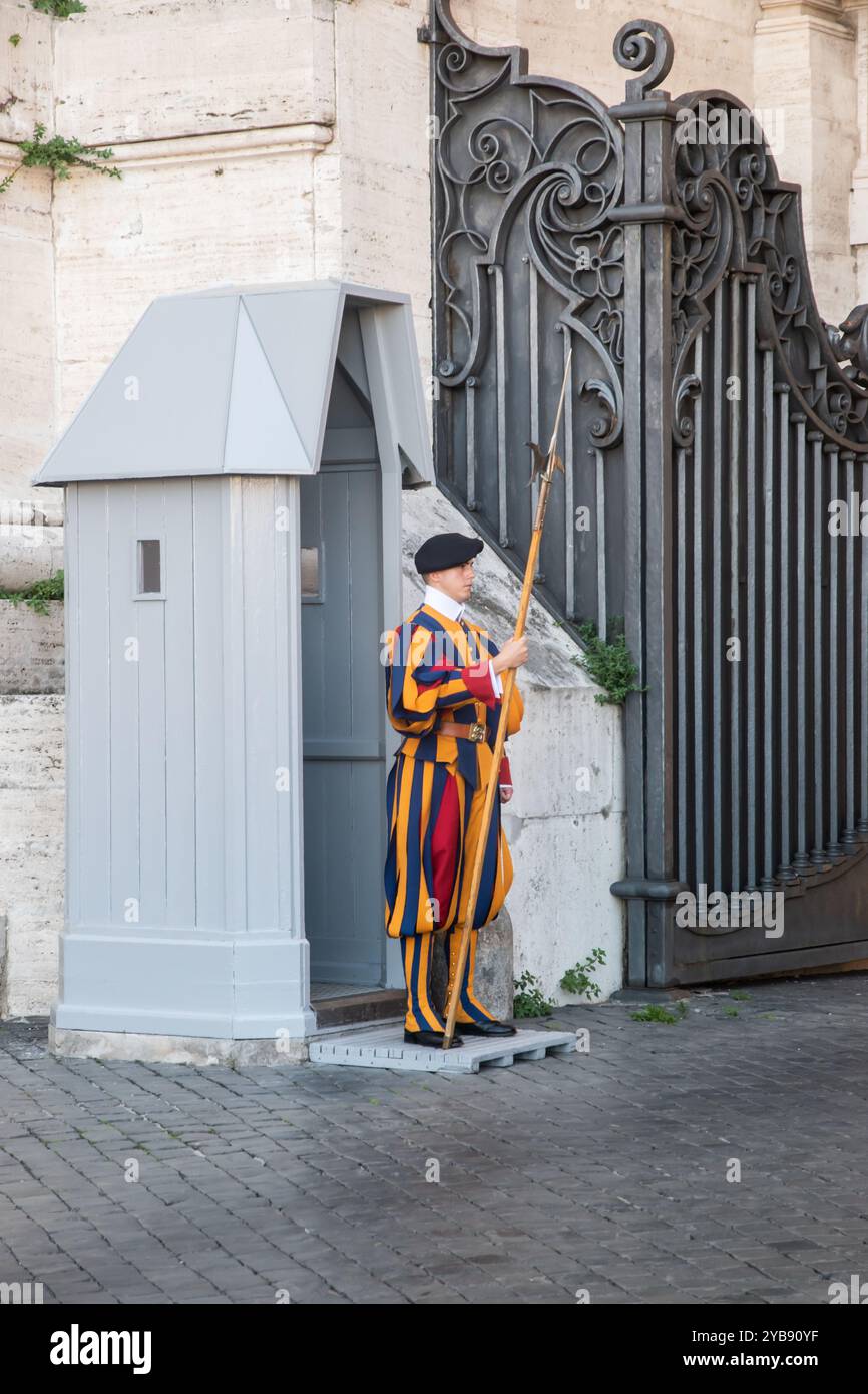 Papal Swiss Guard in uniform with a halberd standing at the door in the ...