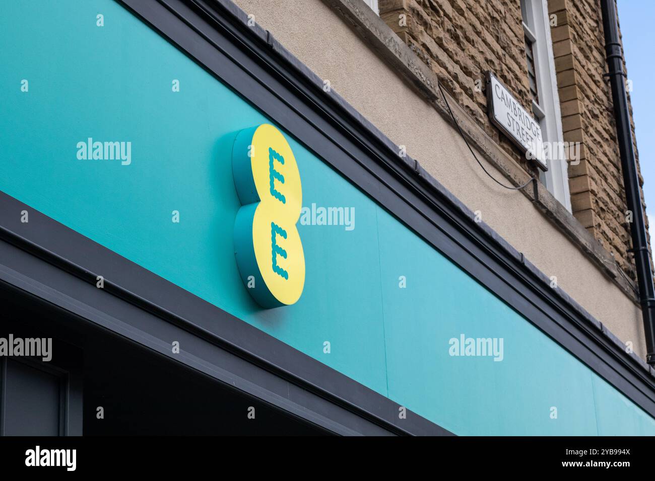 A close-up of the EE logo on a storefront, featuring a bright yellow ...