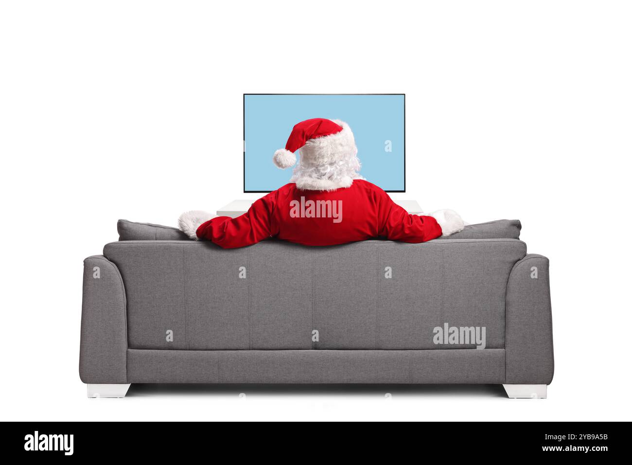 Rear view shot of Santa claus sitting on a sofa and watching tv ...