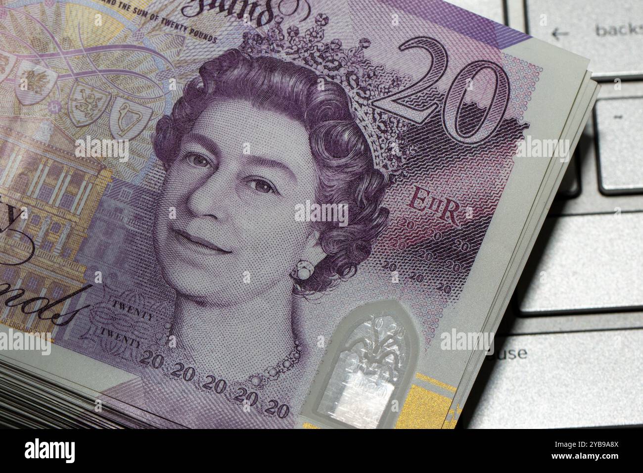 A stack of British 20-pound banknotes placed on a laptop keyboard Stock ...