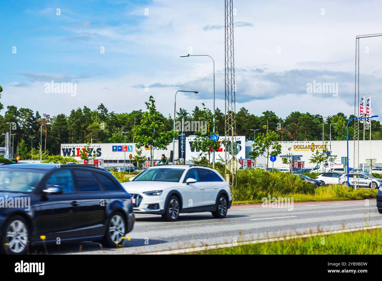 Cars driving past shopping center with popular retail stores during ...