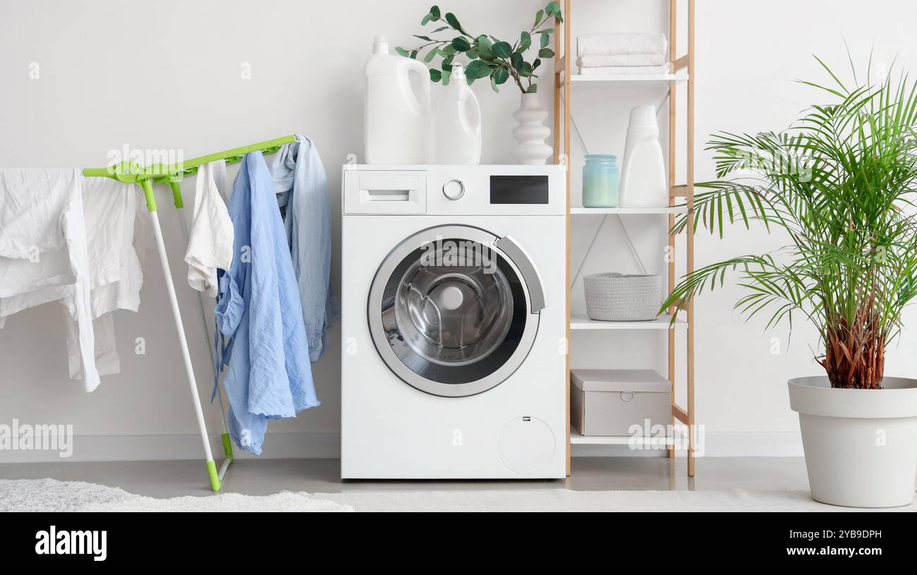 Interior of laundry room with modern washing machine, shelving unit and ...