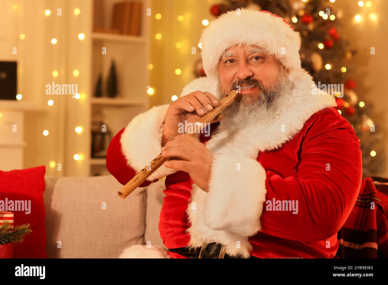 Santa Claus playing woodwind instrument at home on Christmas eve Stock ...