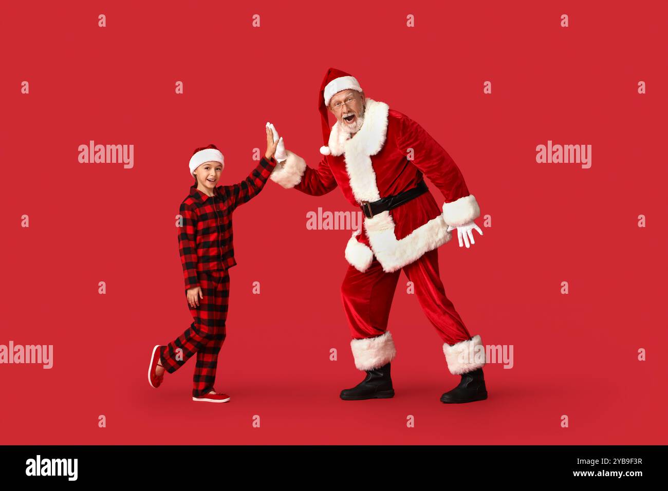 Santa Claus and cute little girl giving high five each other on red ...