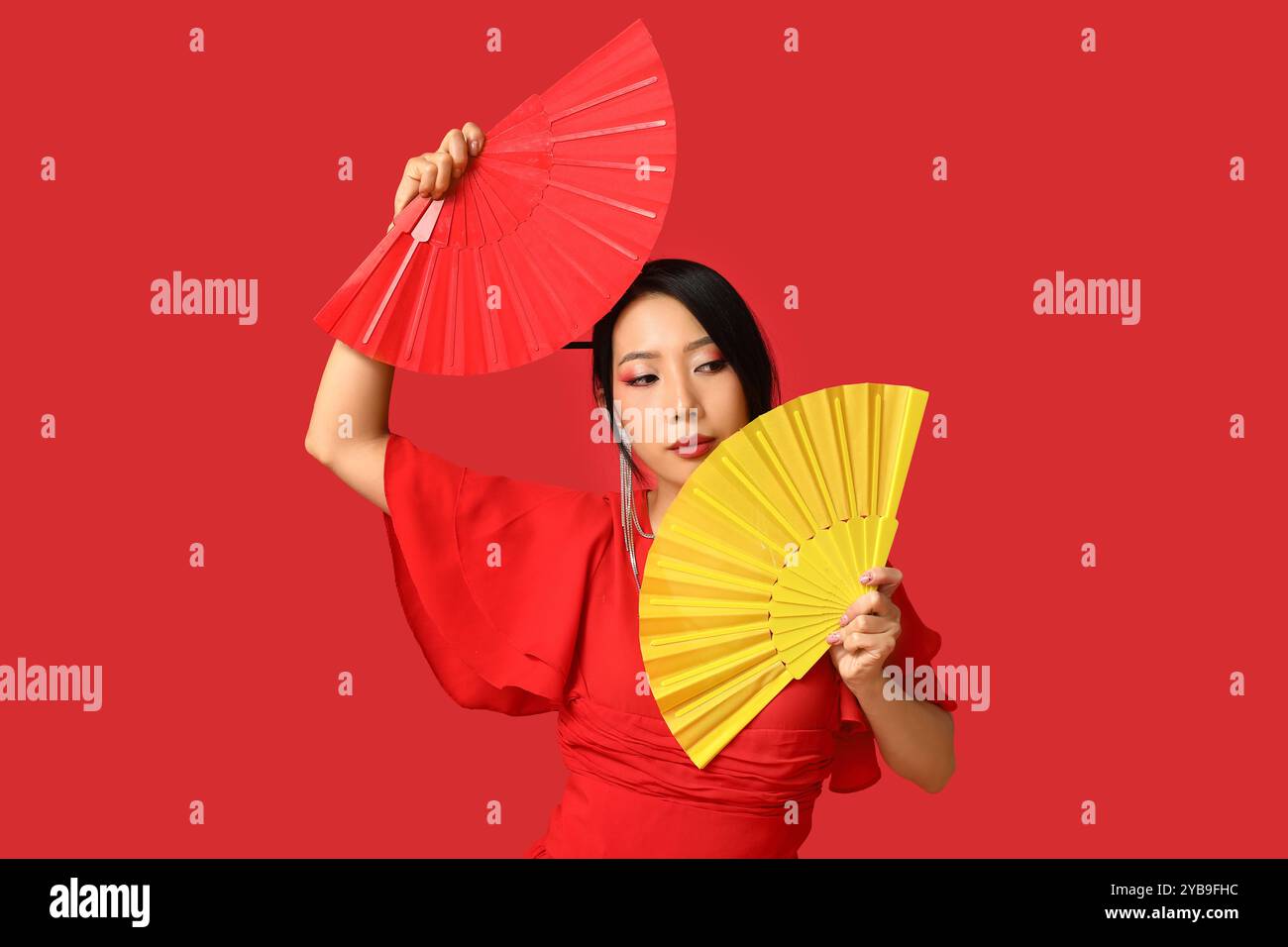 Beautiful young Asian woman with fans on red background. Chinese New ...