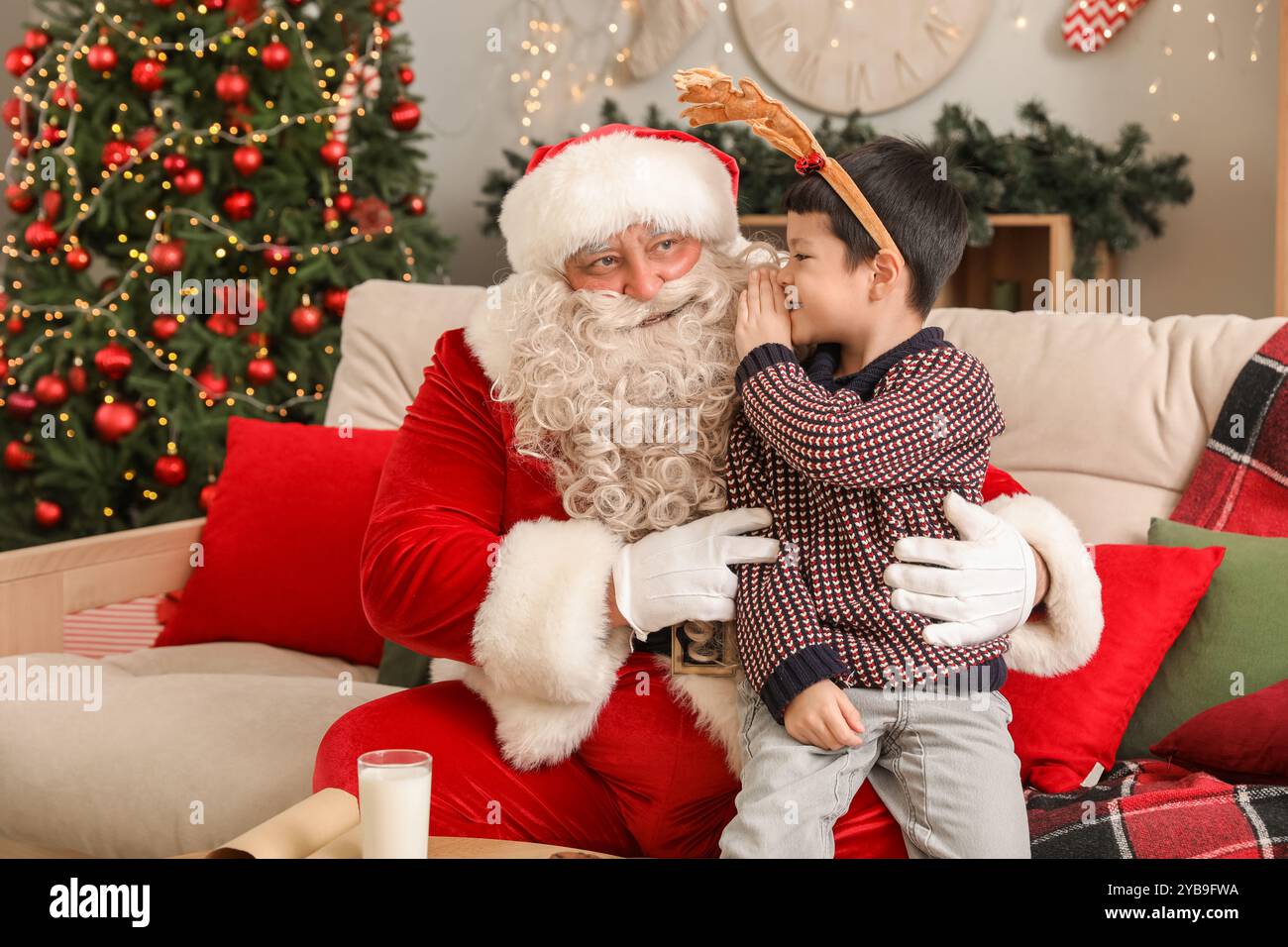 Cute little boy telling wish to Santa Claus at home on Christmas eve ...
