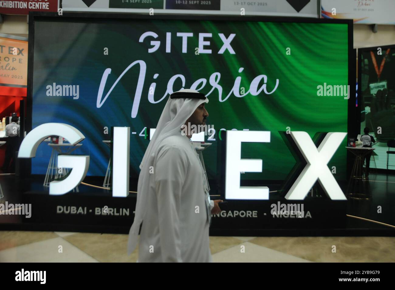 Dubai, United Arab Emirates. 17th Oct, 2024. A man walks past a sign of ...