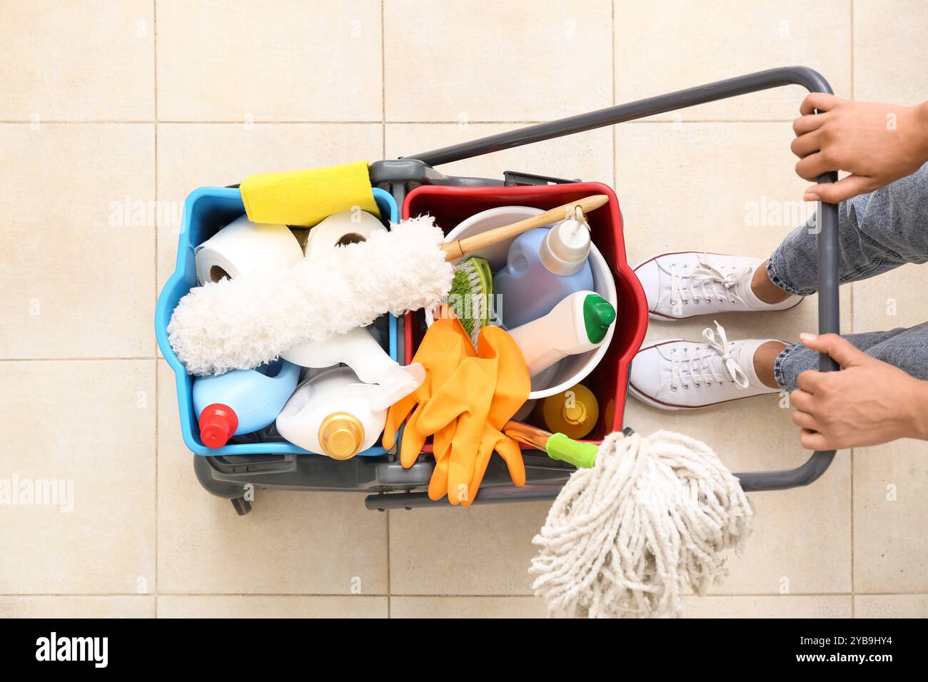 Janitor pushing trolley with cleaning supplies, top view Stock Photo ...