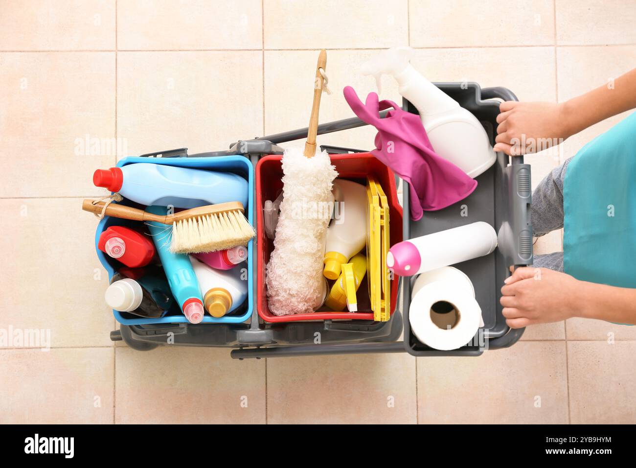Janitor pushing trolley with cleaning supplies, top view Stock Photo ...