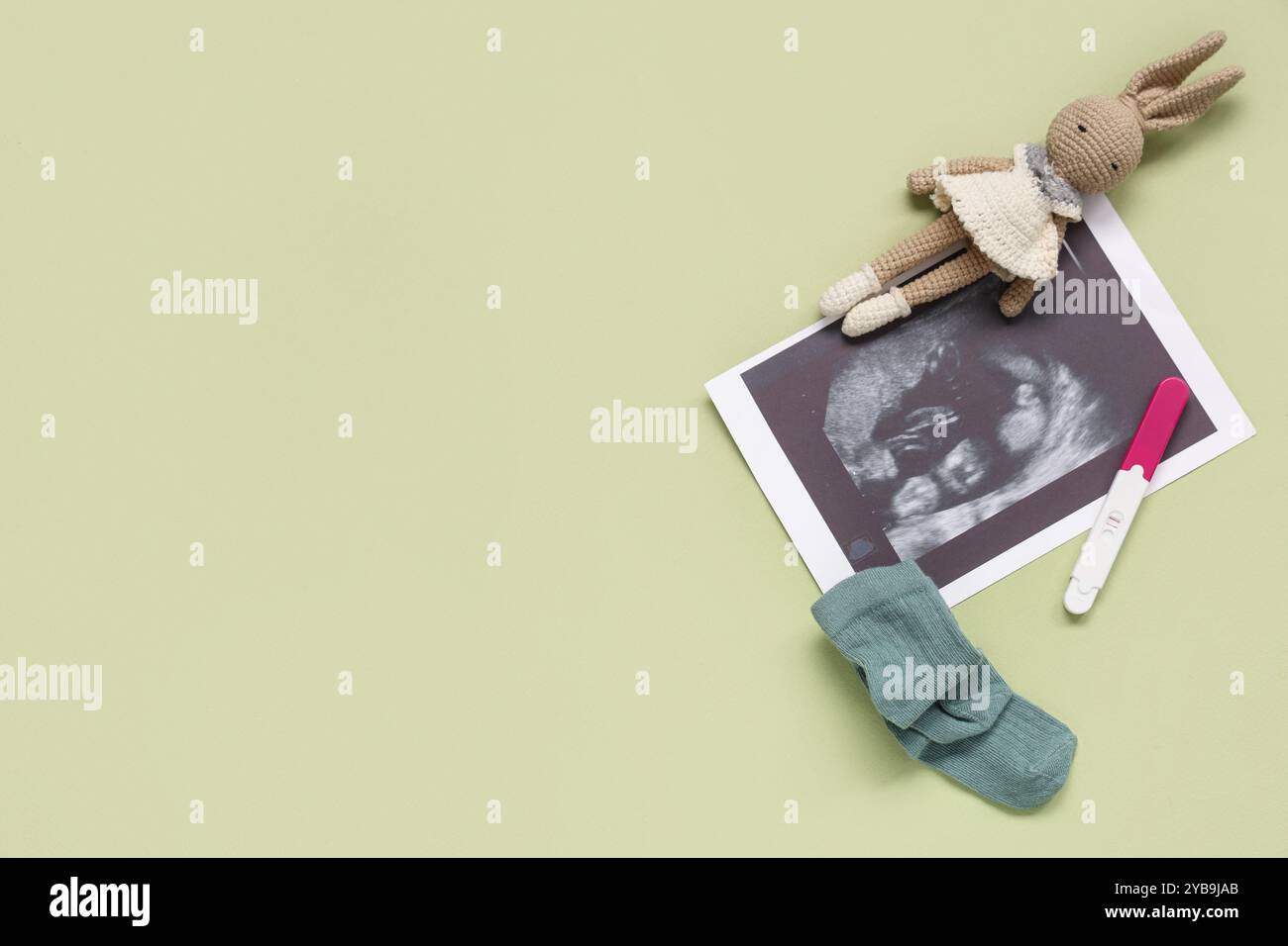 Composition with baby socks, sonogram image, toy rabbit and pregnancy ...