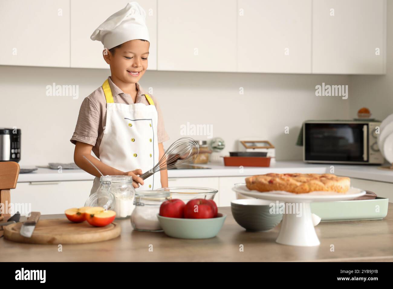 Cute little Asian chef cooking in kitchen Stock Photo - Alamy