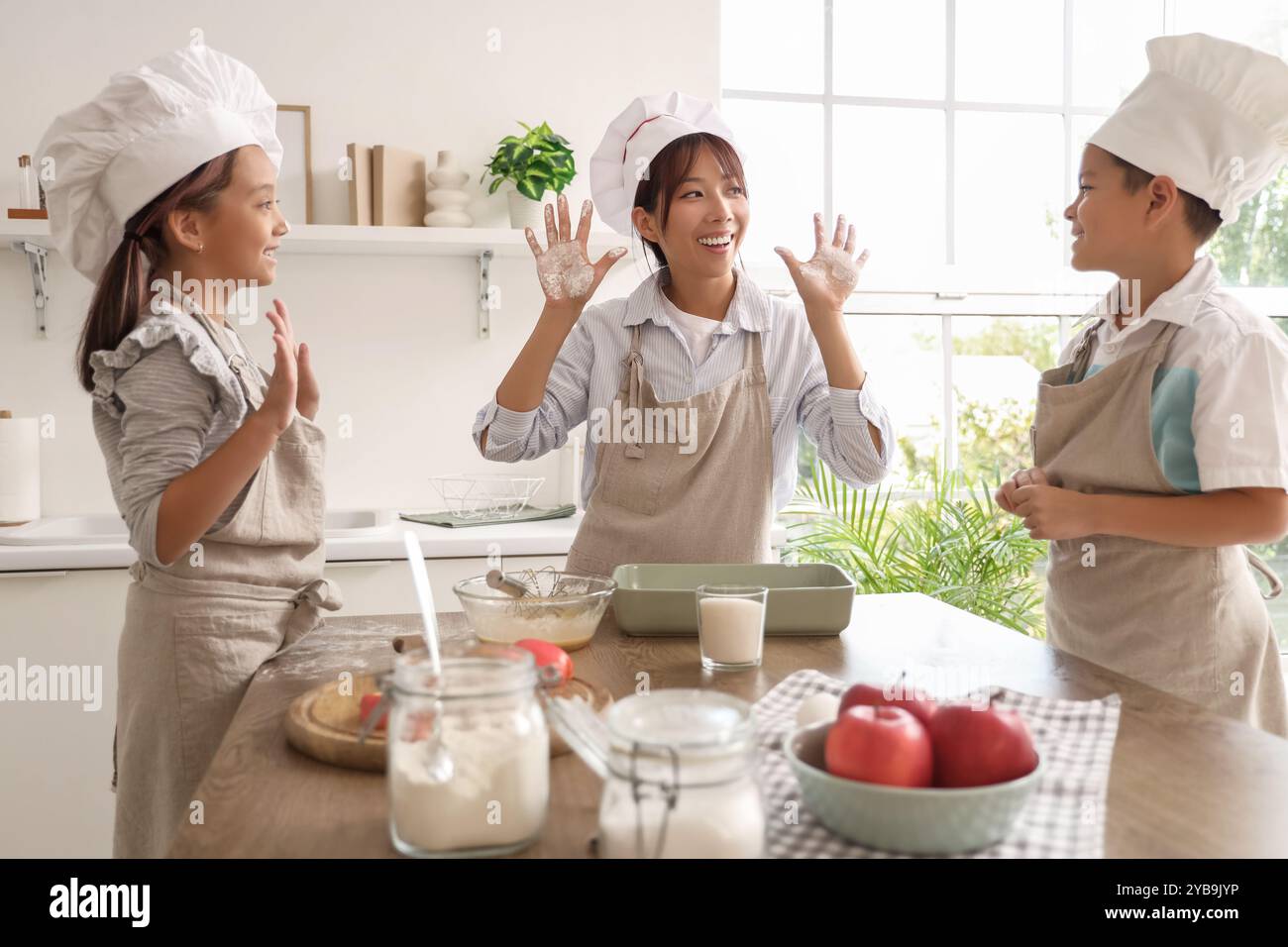 Female Asian chef with her little children cooking in kitchen Stock ...