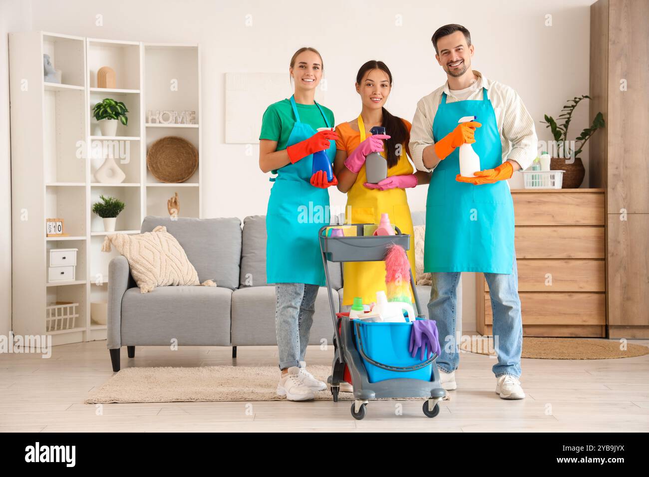 Team of janitors with cleaning supplies in room Stock Photo - Alamy