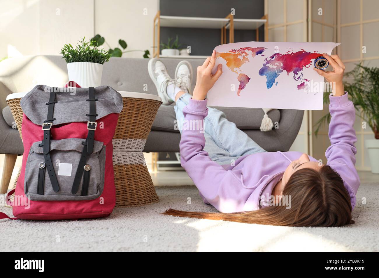 Female tourist with compass and map lying on floor at home Stock Photo ...
