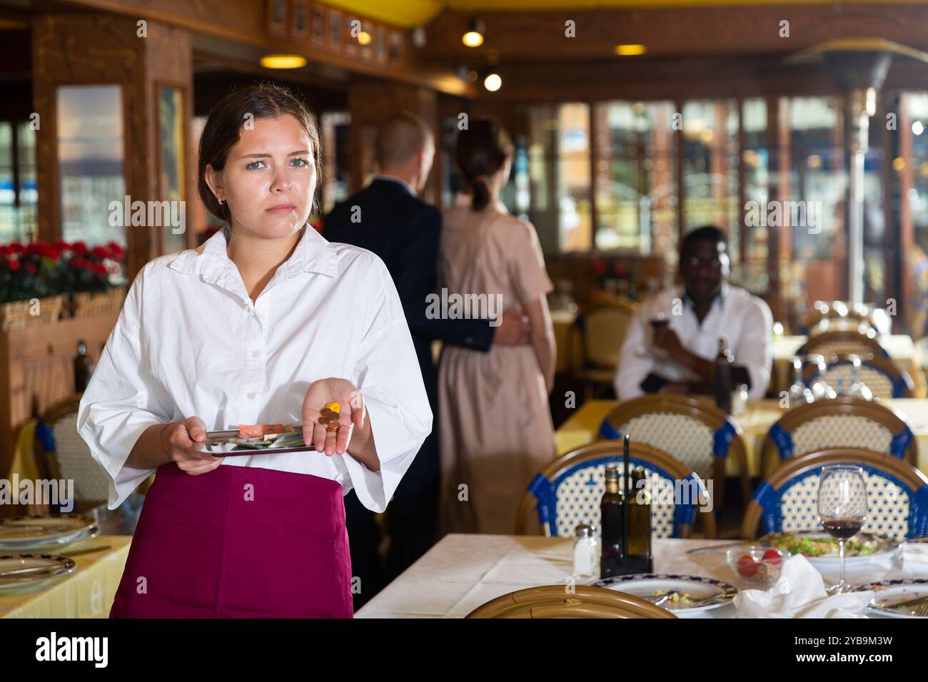 Waitress disappointed in small tip from guests Stock Photo - Alamy