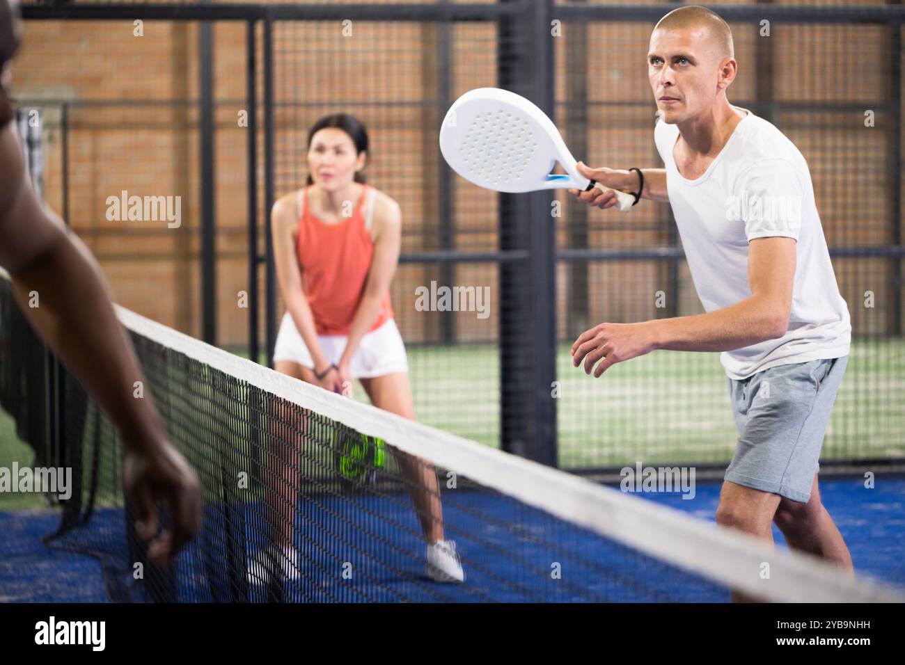 Concentrated paddle tennis player preparing to hit forehand Stock Photo ...