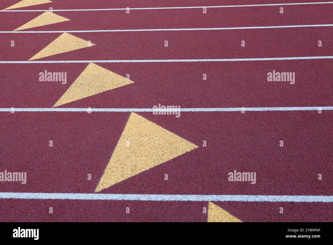 Red rubber running track lanes with white lines and yellow markings ...
