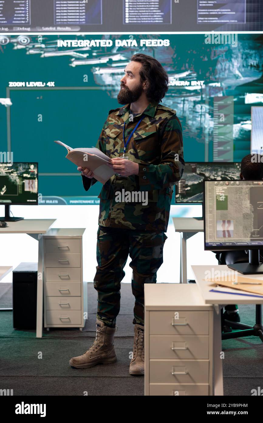 Military personnel examining live satellite imagery on a big screen in ...