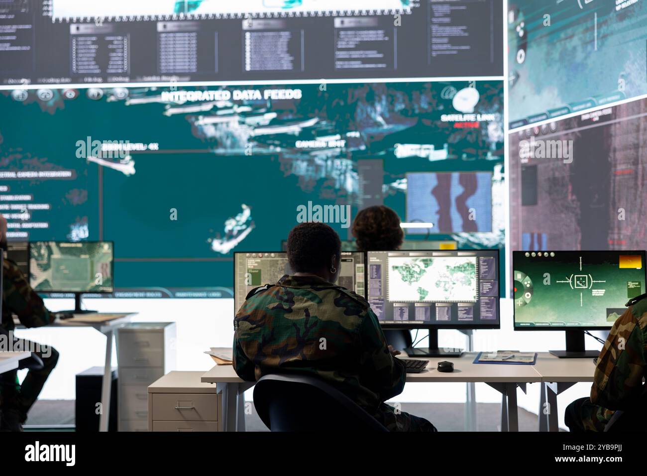 Army staff examining surveillance footage on big screen in operation ...