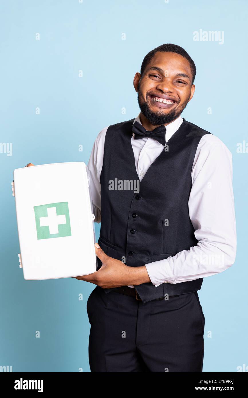 Hotel employee presenting a first aid kit used for medical emergencies ...