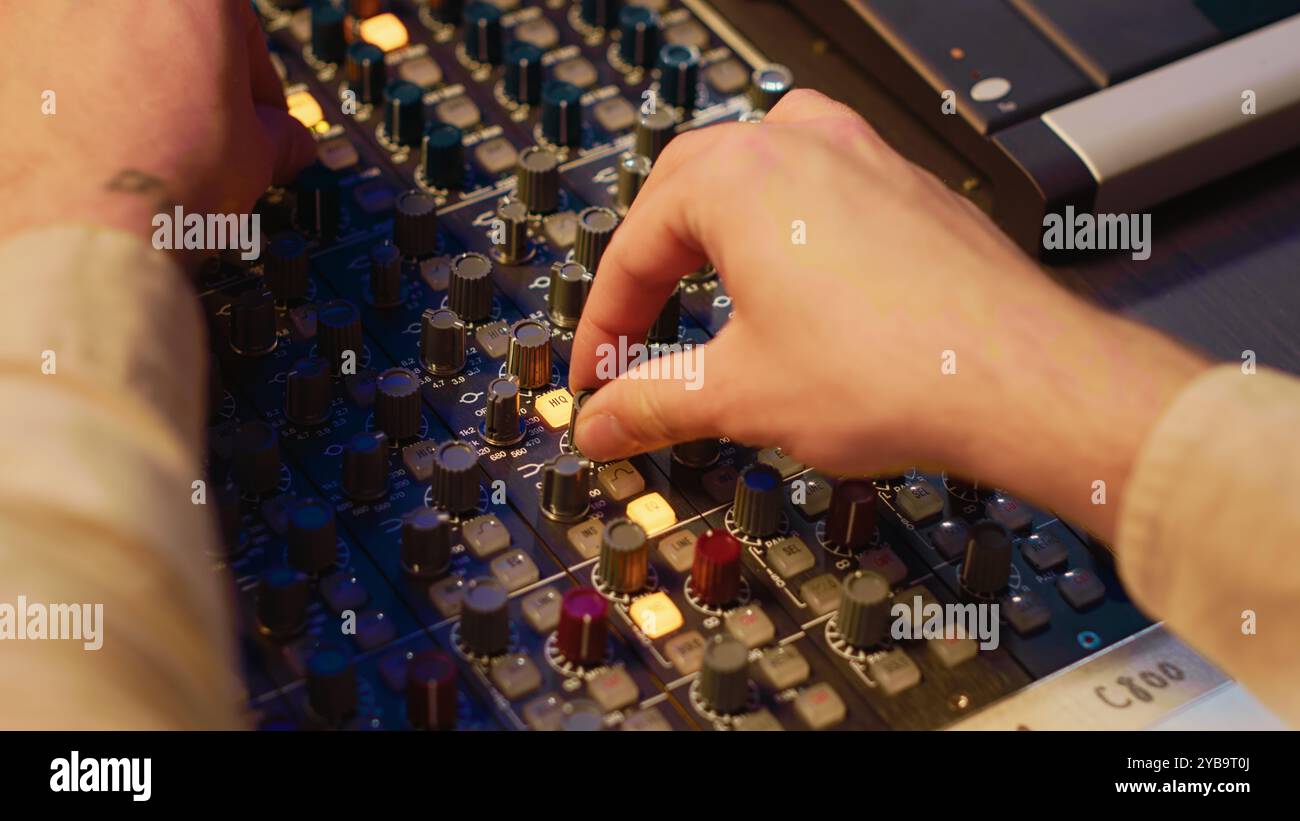 Audio technician twisting pre amp knobs and buttons on panel board in ...