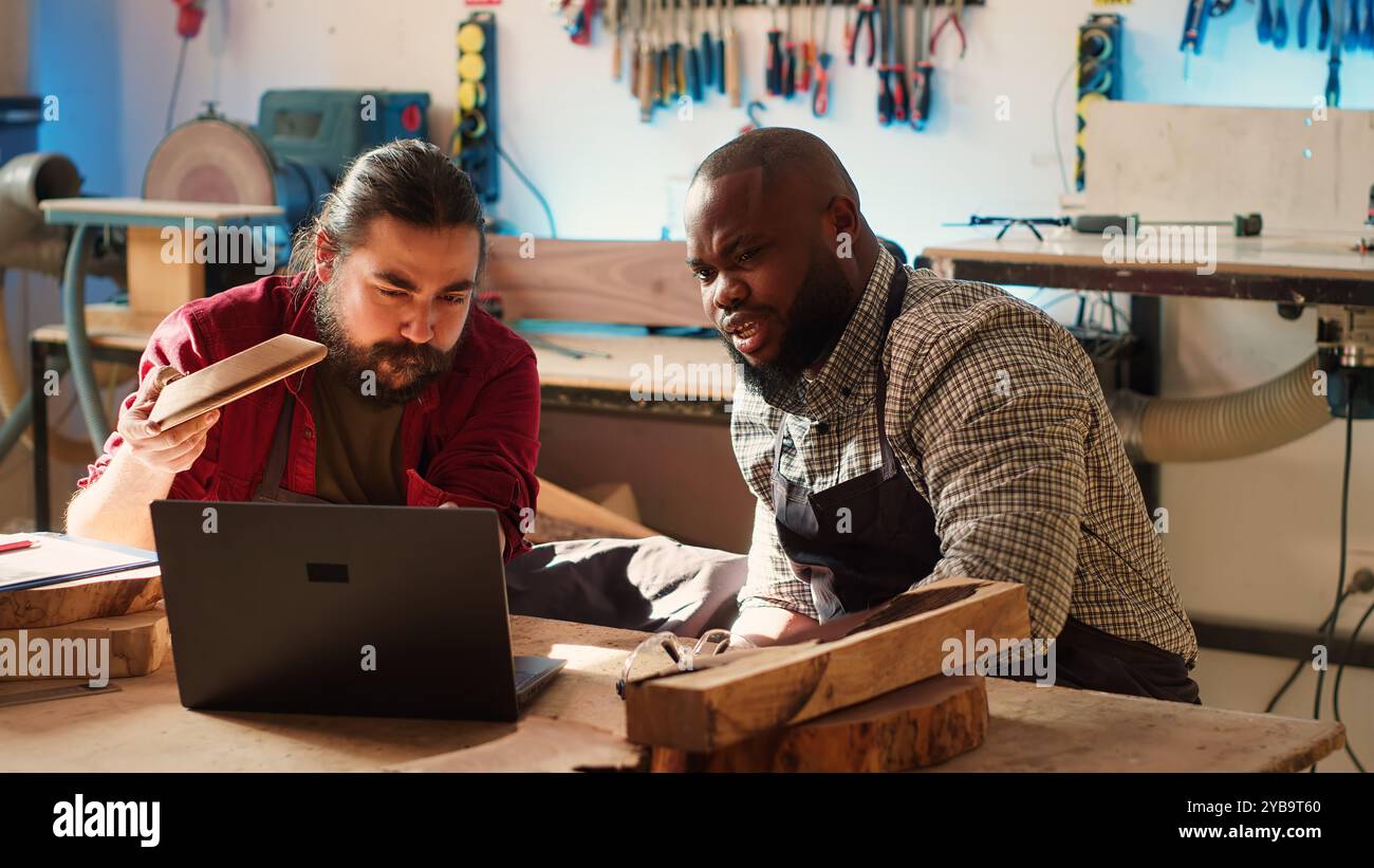 Carpenter and colleague verifying finished wood art product, comparing ...