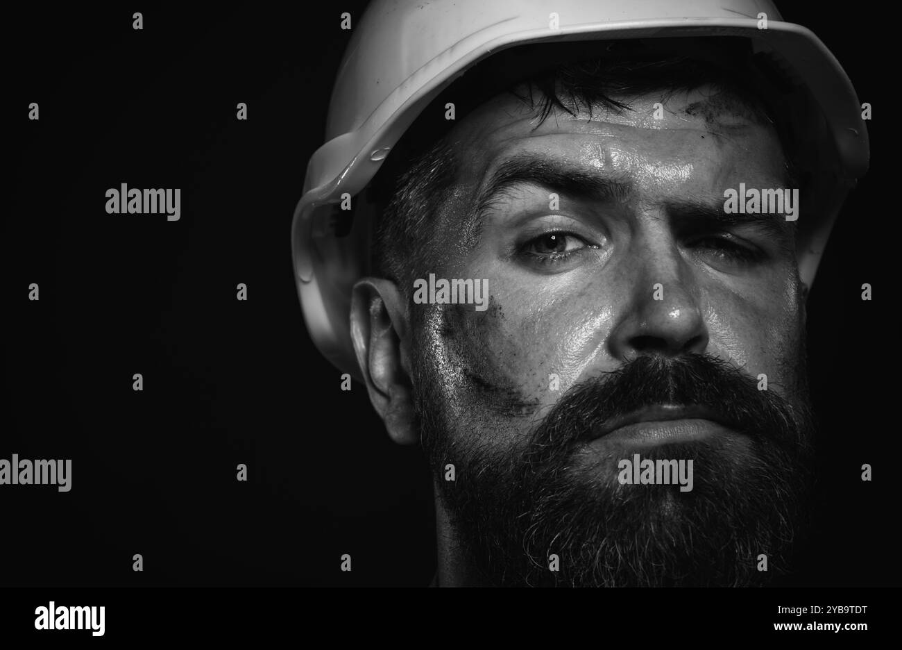 Closeup portrait of serious male builder with dirty face in hard hat ...