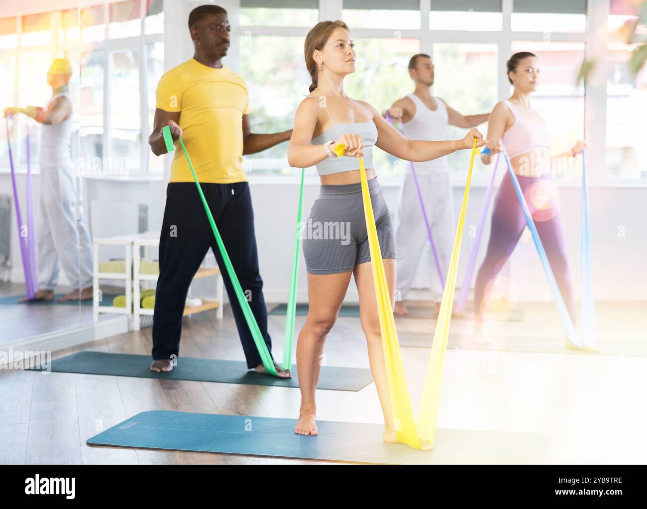Group of athletes train in Pilates class using elastic bands Stock ...